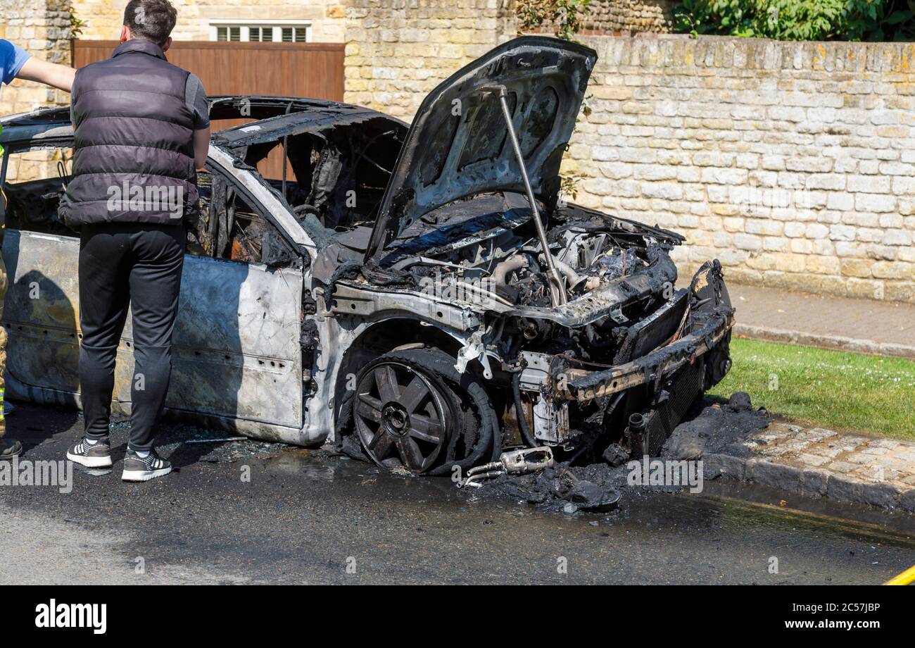 A completely burnt out car at the side of the road in High Street ...