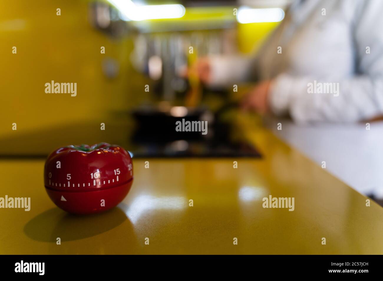 Timer to count the time on the yellow surface of a kitchen with a pan ...