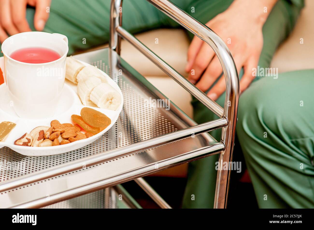 Tea drinking with dried fruits between two male doctors and a woman in ...