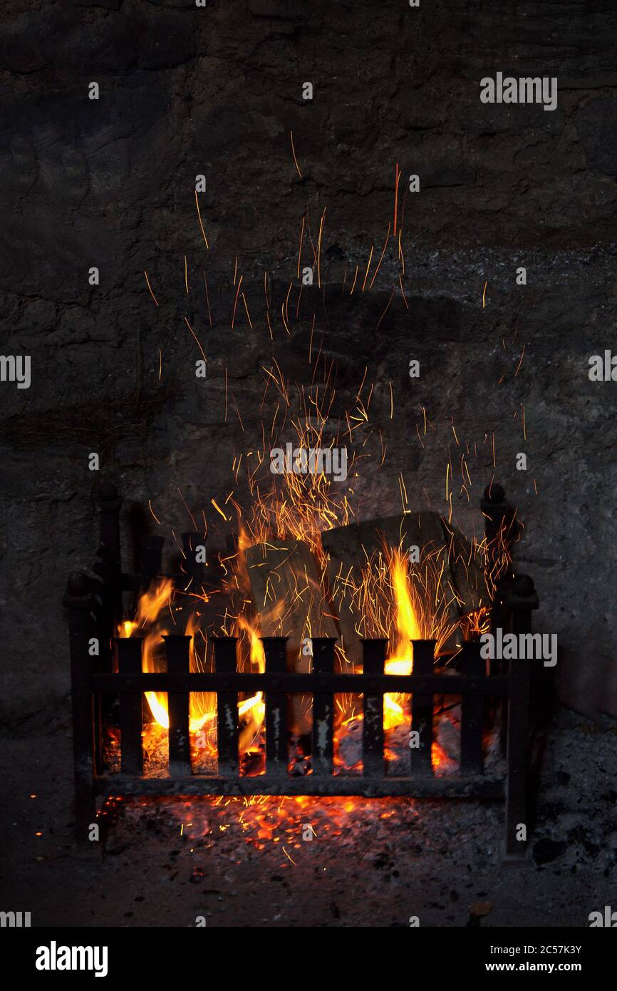 Old fashioned open log fireplace in with flames and sparks Stock Photo ...