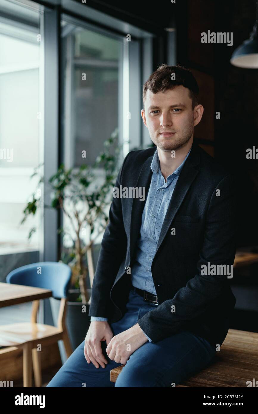Executive manager portrait looking at camera standing in modern loft ...