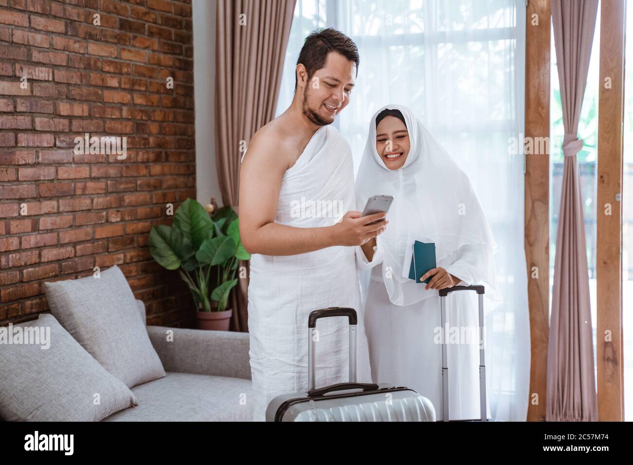 portrait of muslim couple making a phone call while umrah and hajj ...
