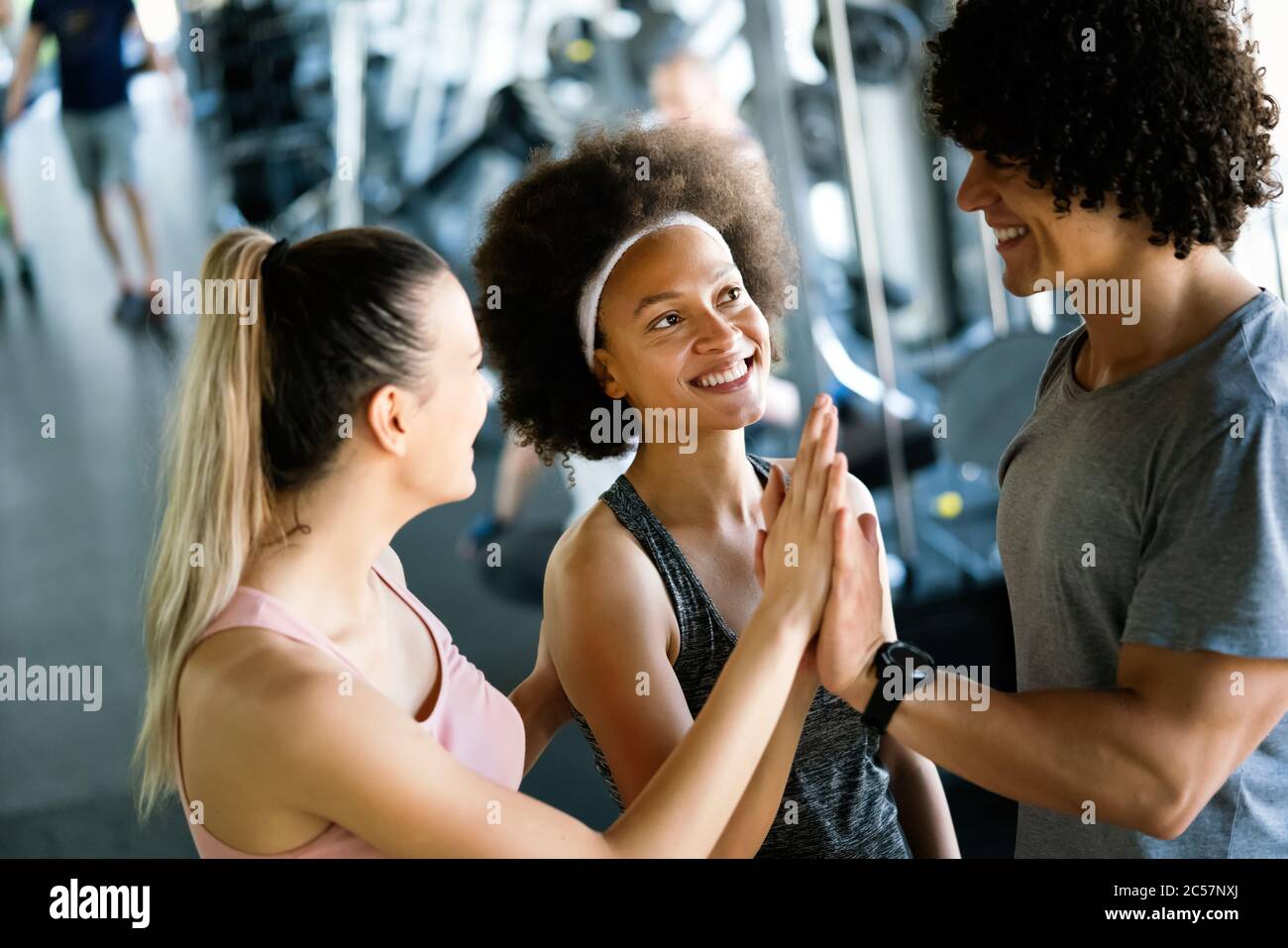 Happy fitness class giving high-five after completing exercise. Group ...