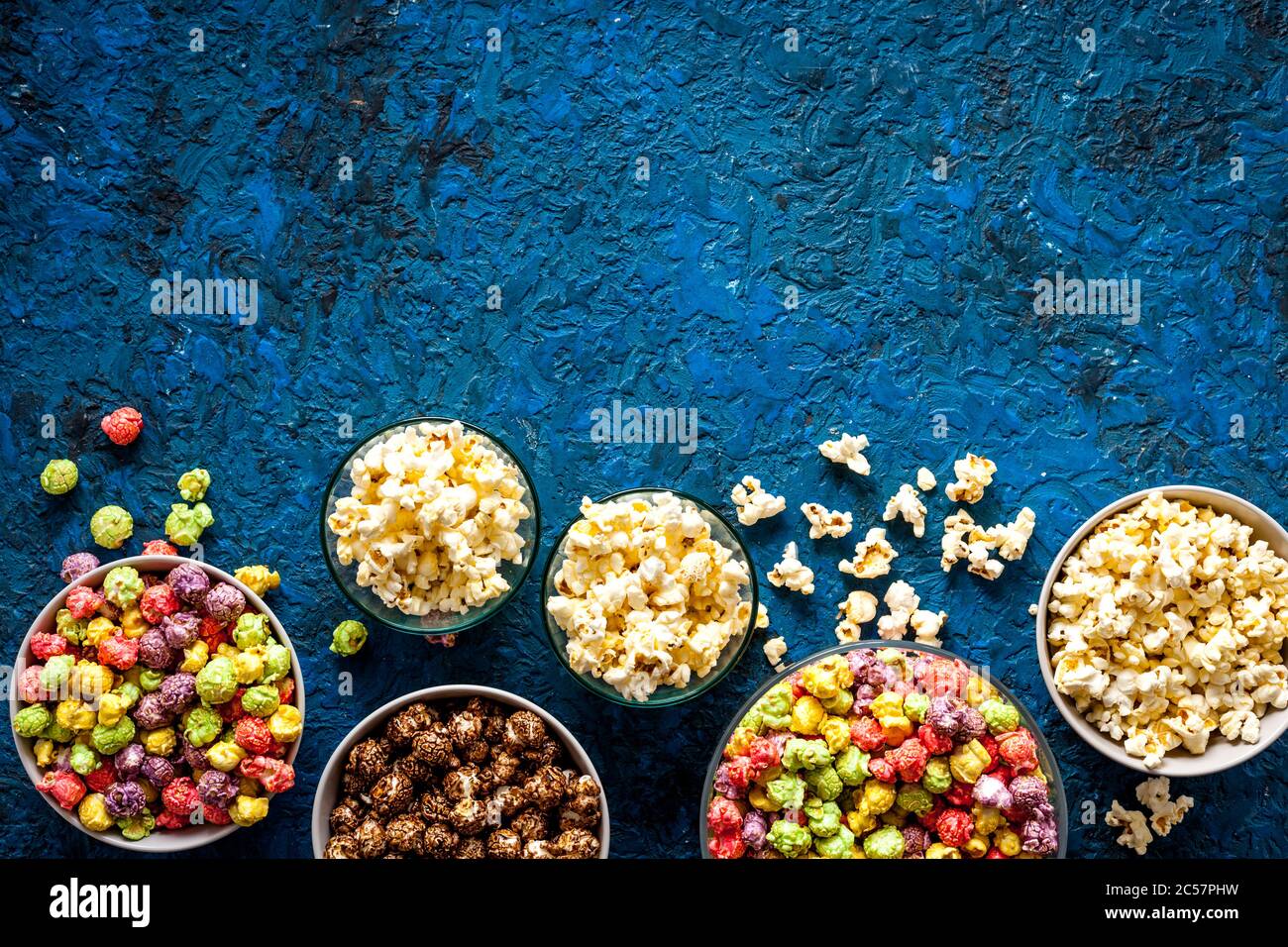 Colorful popcorn in bowl on blue table top-down copy space Stock Photo ...