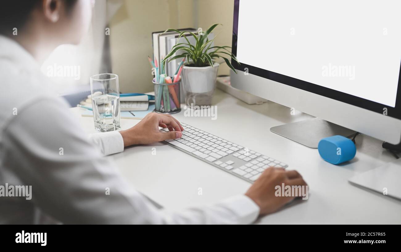 The office worker is working with a white blank screen computer at the ...