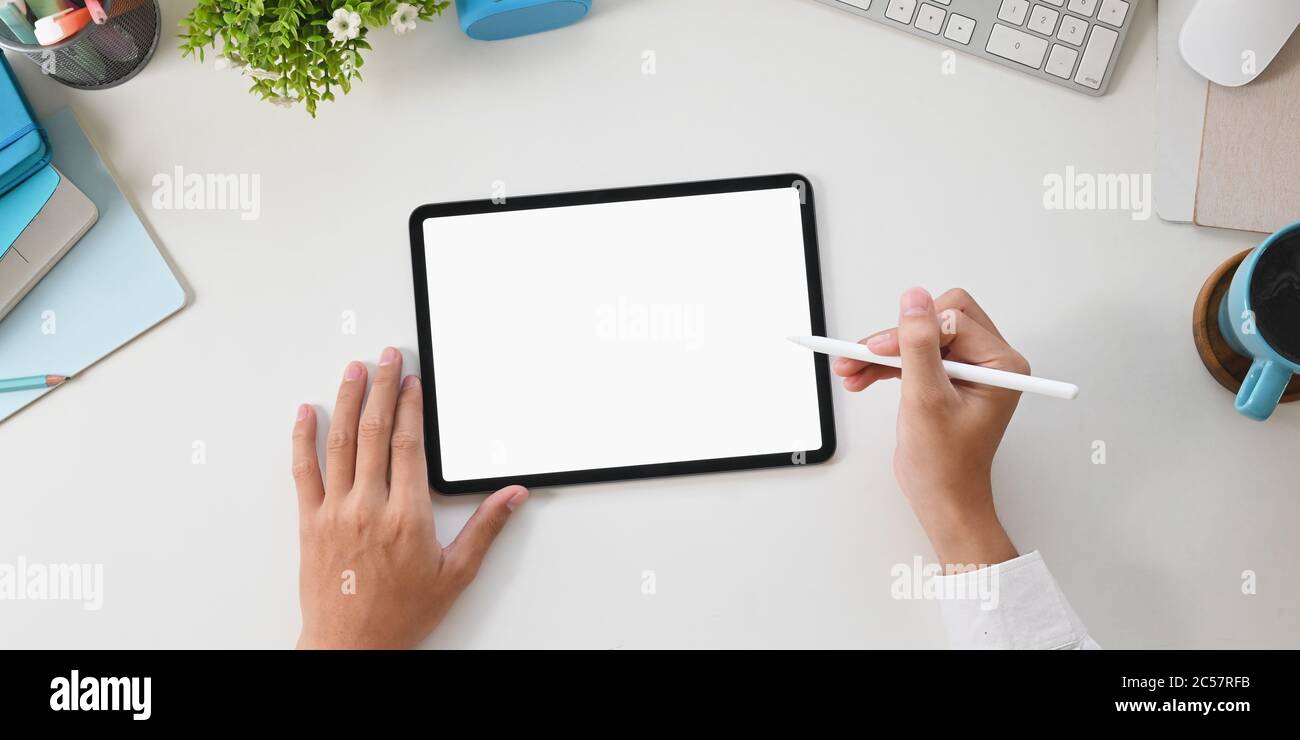 Top view working desk hands are drawing on a white blank screen ...