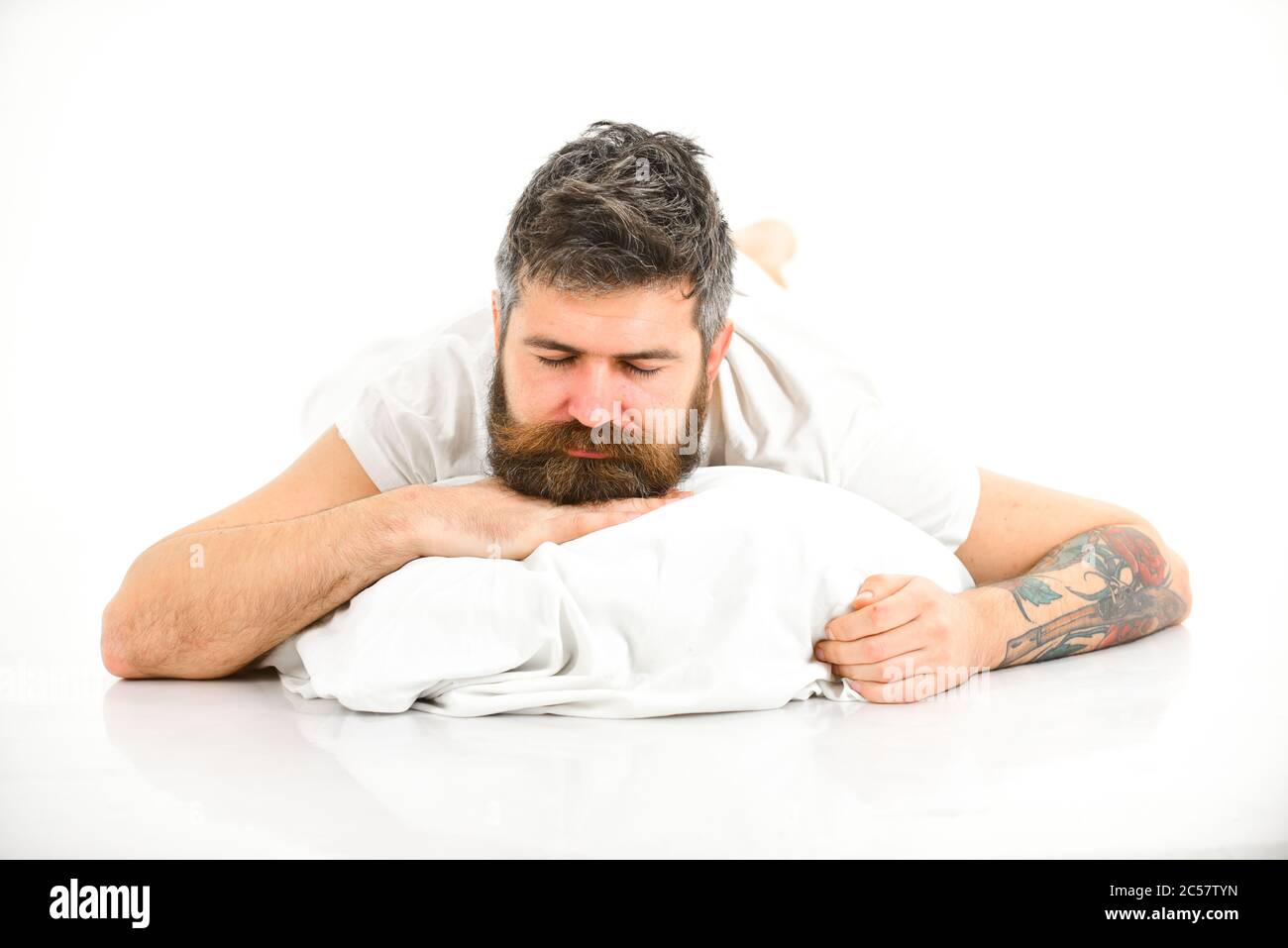 Man with sleepy face lies on pillow. Man with beard and mustache in ...