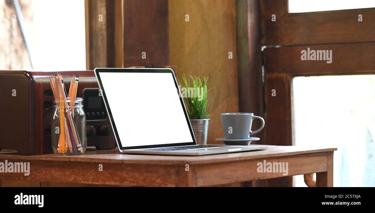 A computer laptop with a white blank screen is putting on a wooden ...