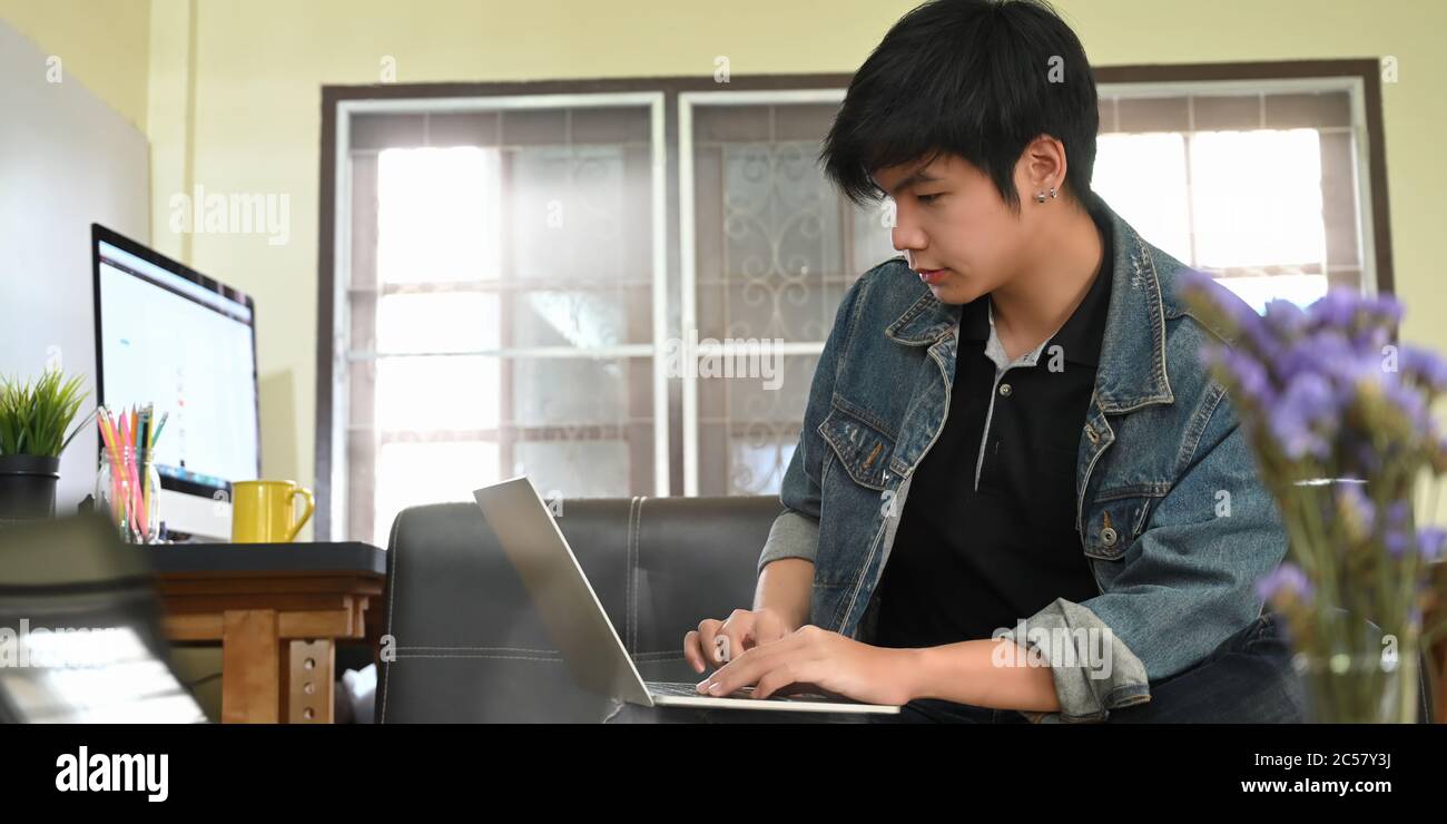 Smart man in jean shirt typing on computer laptop that putting on his ...