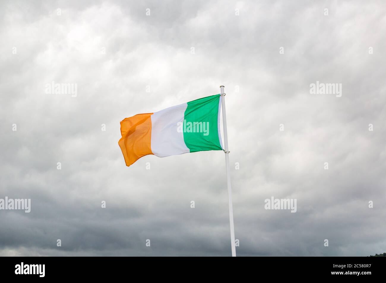 Irish flag waving in the wind against cloudy sky Stock Photo - Alamy