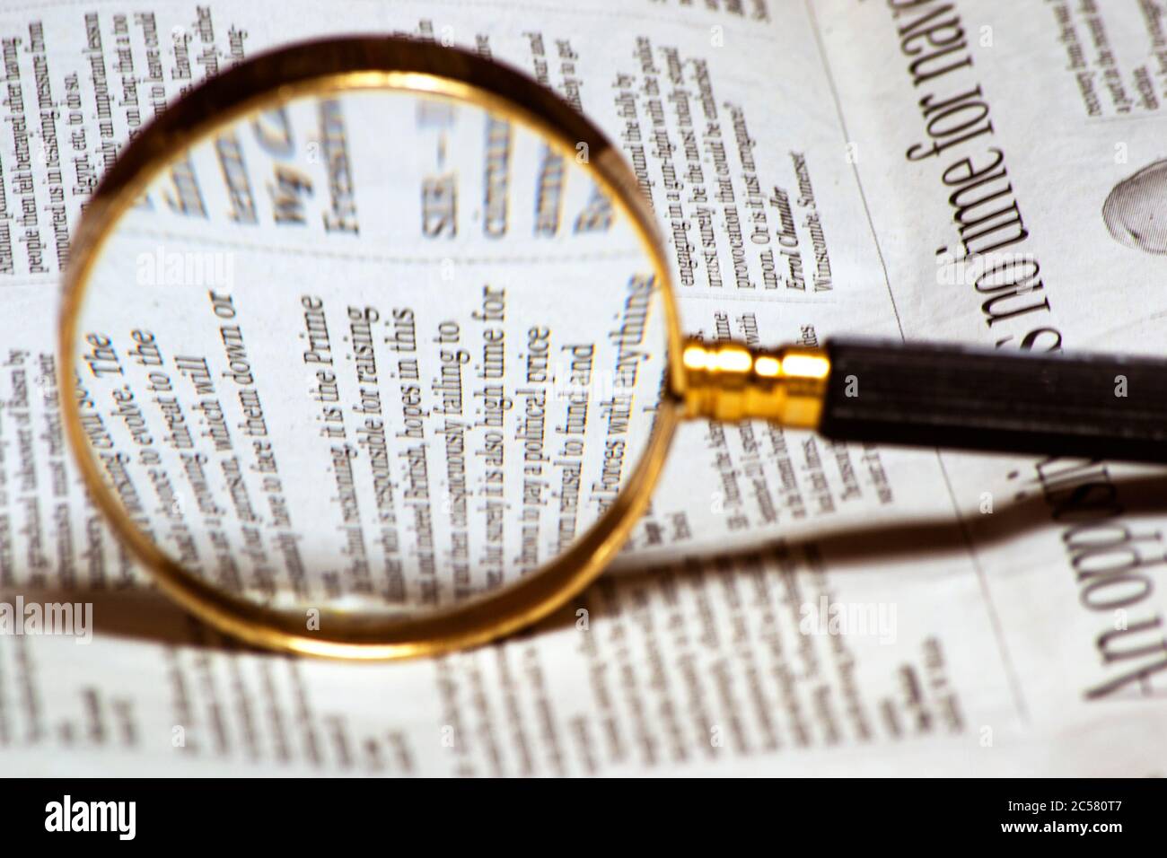 old style magnifying glass lens and newspaper. concept for fact ...