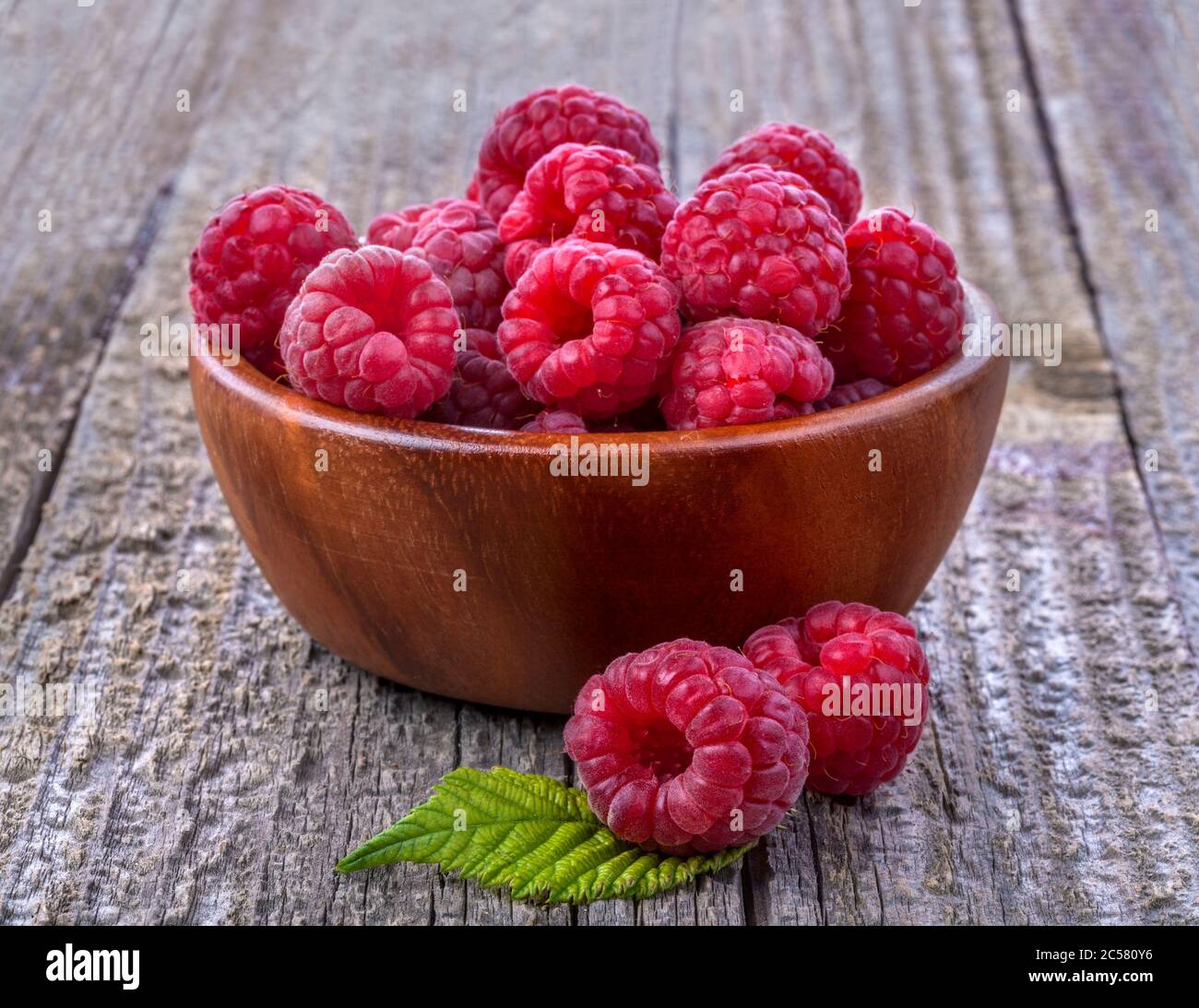 Ripe sweet healthy organic raspberries in a bowl on the old rustic ...