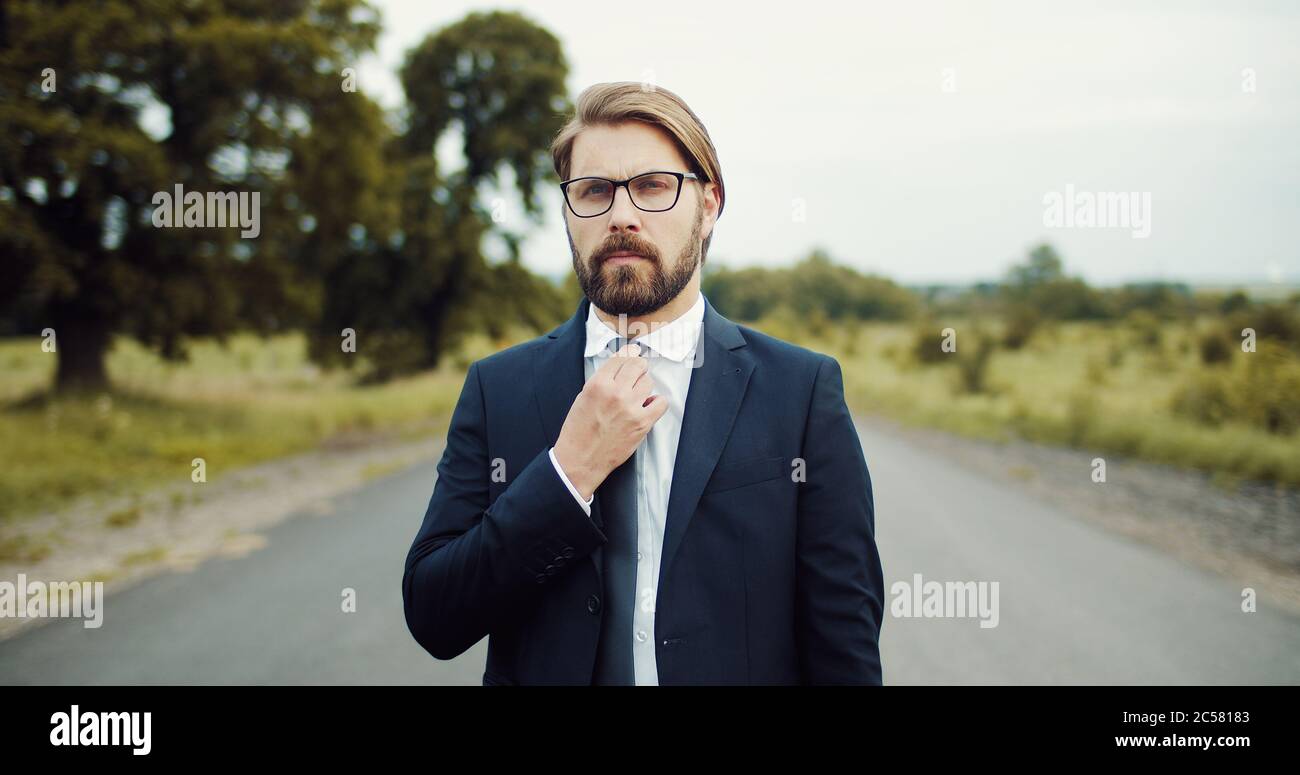 Businessman standing middle country road Stock Photo - Alamy