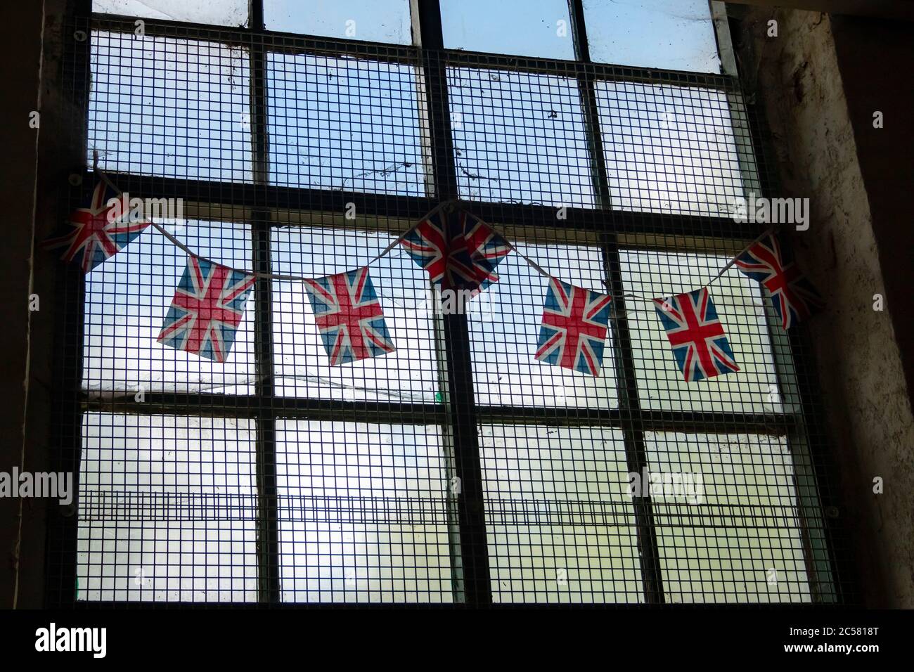 union jack flags on bunting across old grilled window Stock Photo - Alamy