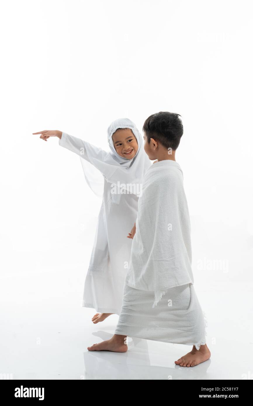 cute little kid wearing muslim ihram clothes and dress holding hand and ...