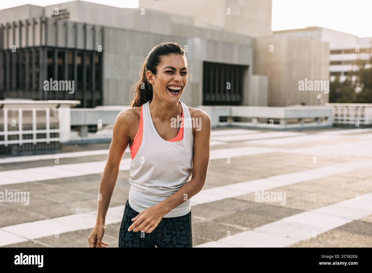 Fitness woman laughing after morning run in the city. Fit female ...