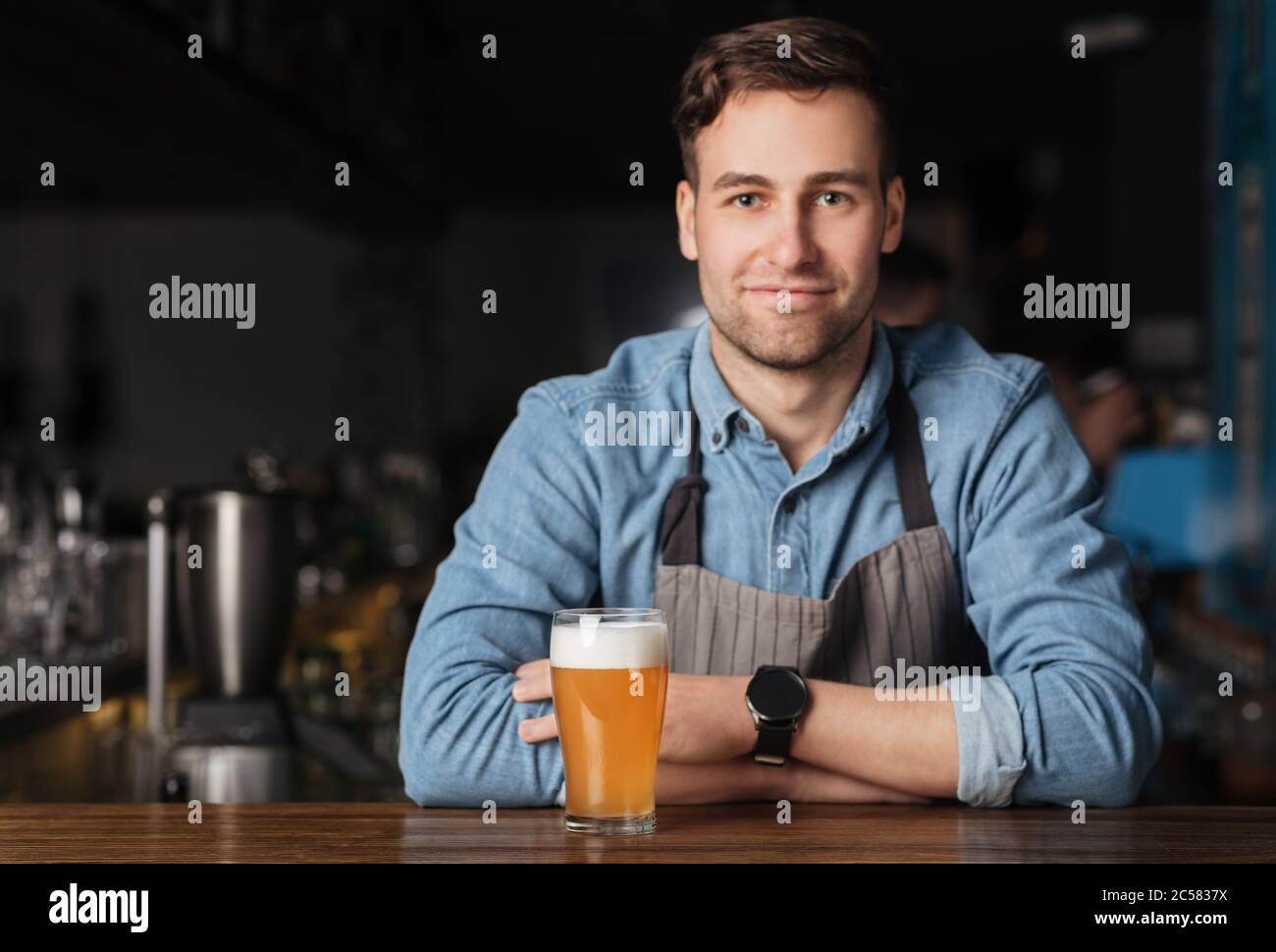 Friday at pub with drinks. Handsome barman at bar counter with ...