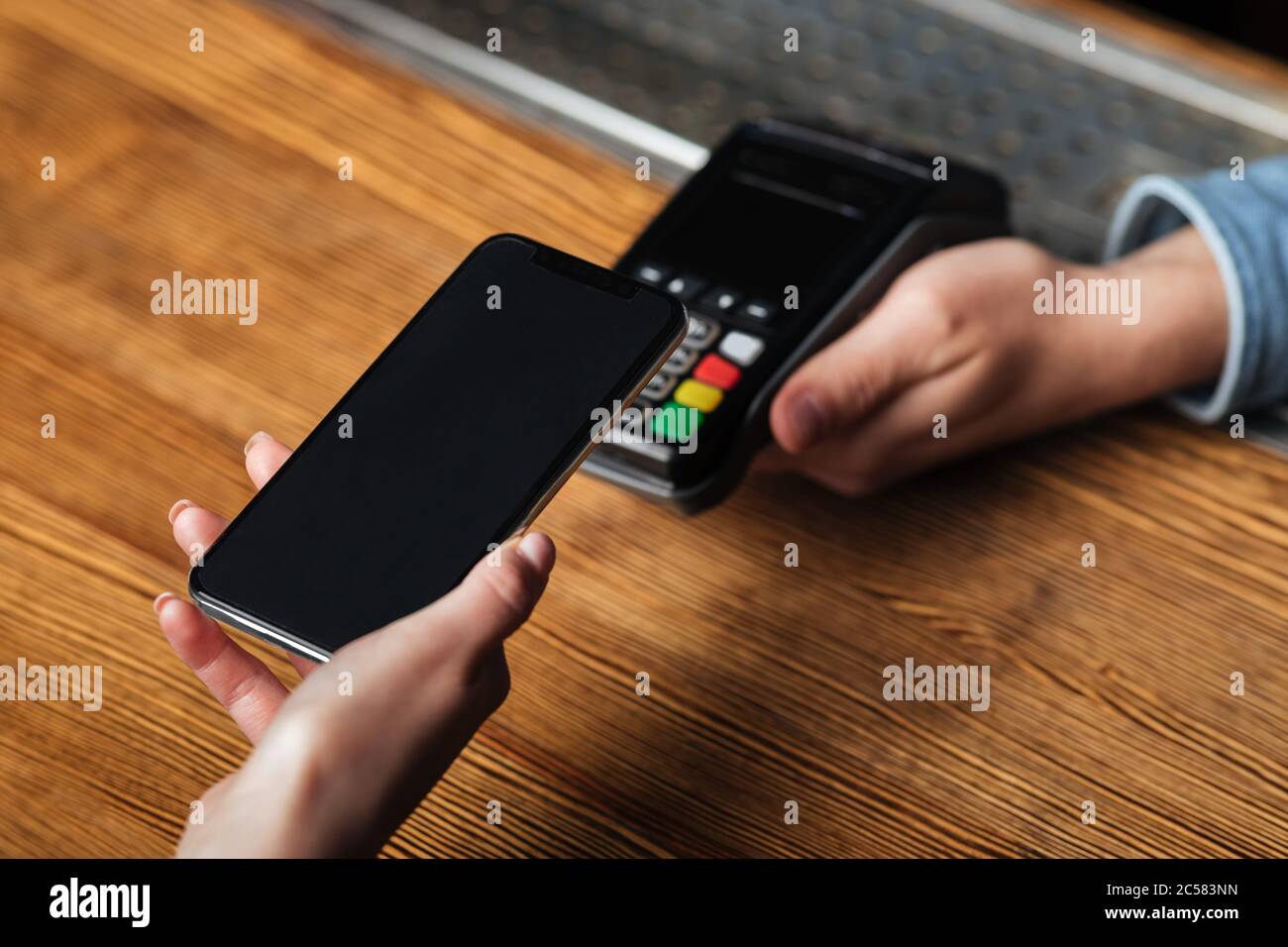 Modern contactless payment of bill by smartphone. Hands of woman client ...