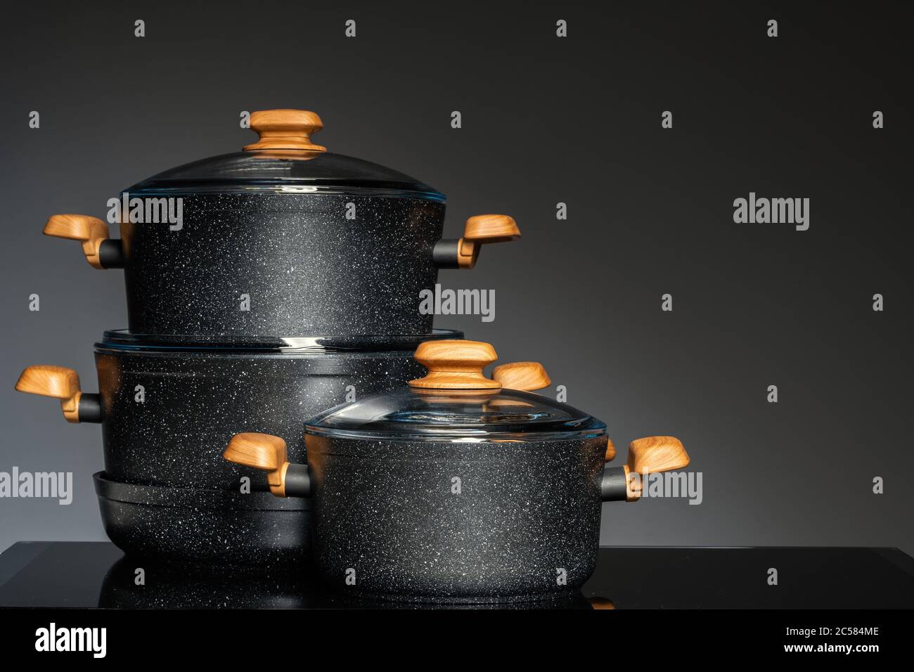 New cookware on black background, front view Stock Photo - Alamy