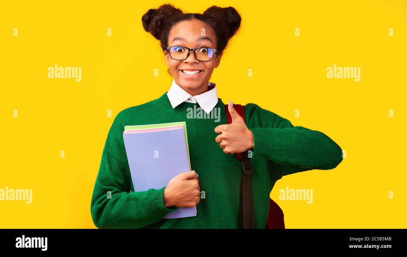 Smiling afro teen girl showing thumb up Stock Photo - Alamy