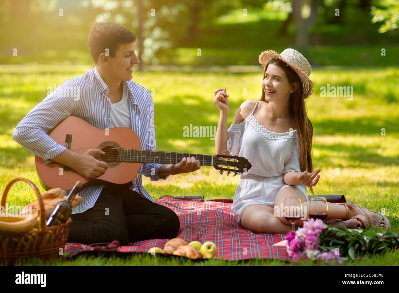 Affectionate boyfriend playing guitar and singing song for his ...