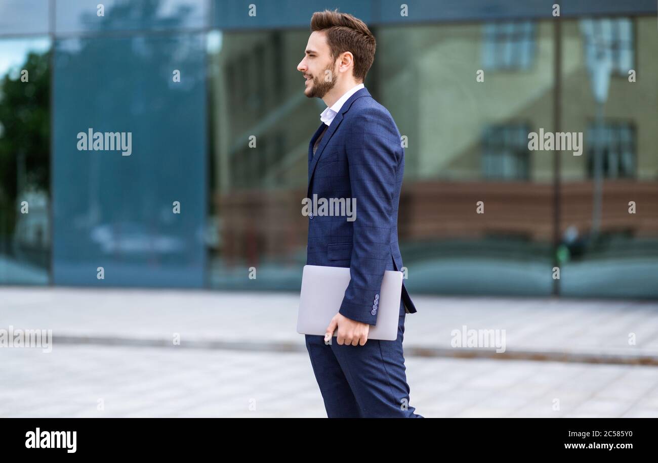 Successful trader in business suit holding tablet computer in central ...