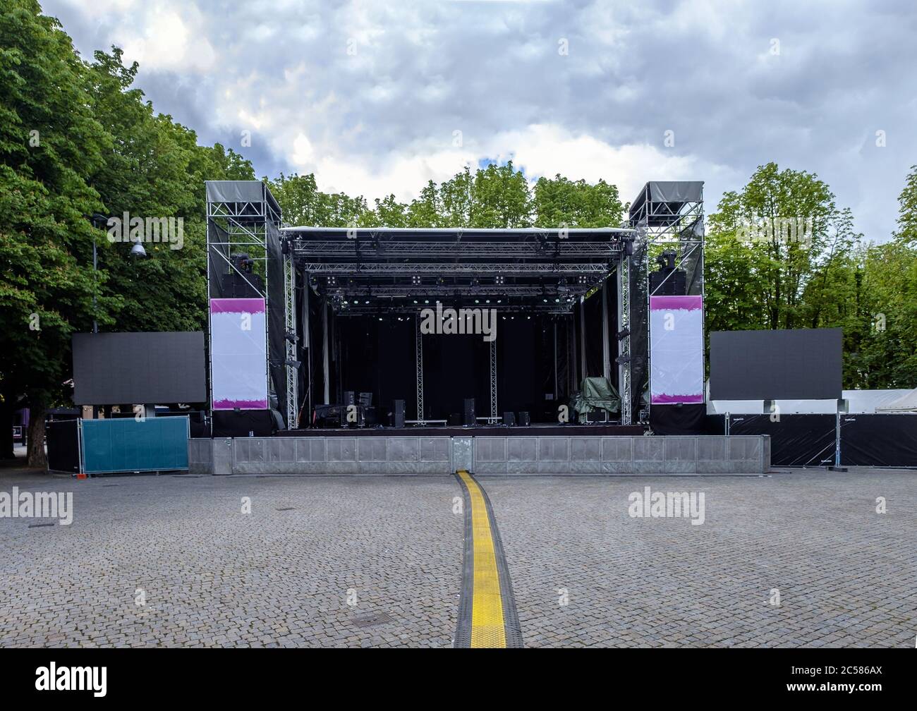 Outdoor empty concert stage in front of green trees during daylight ...
