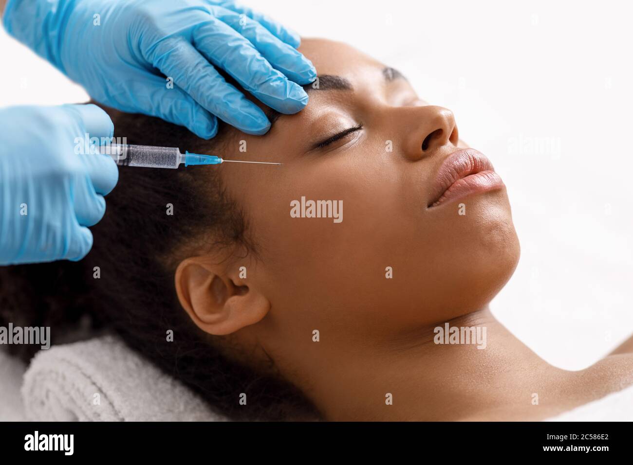 Black woman getting eye injection at salon Stock Photo - Alamy