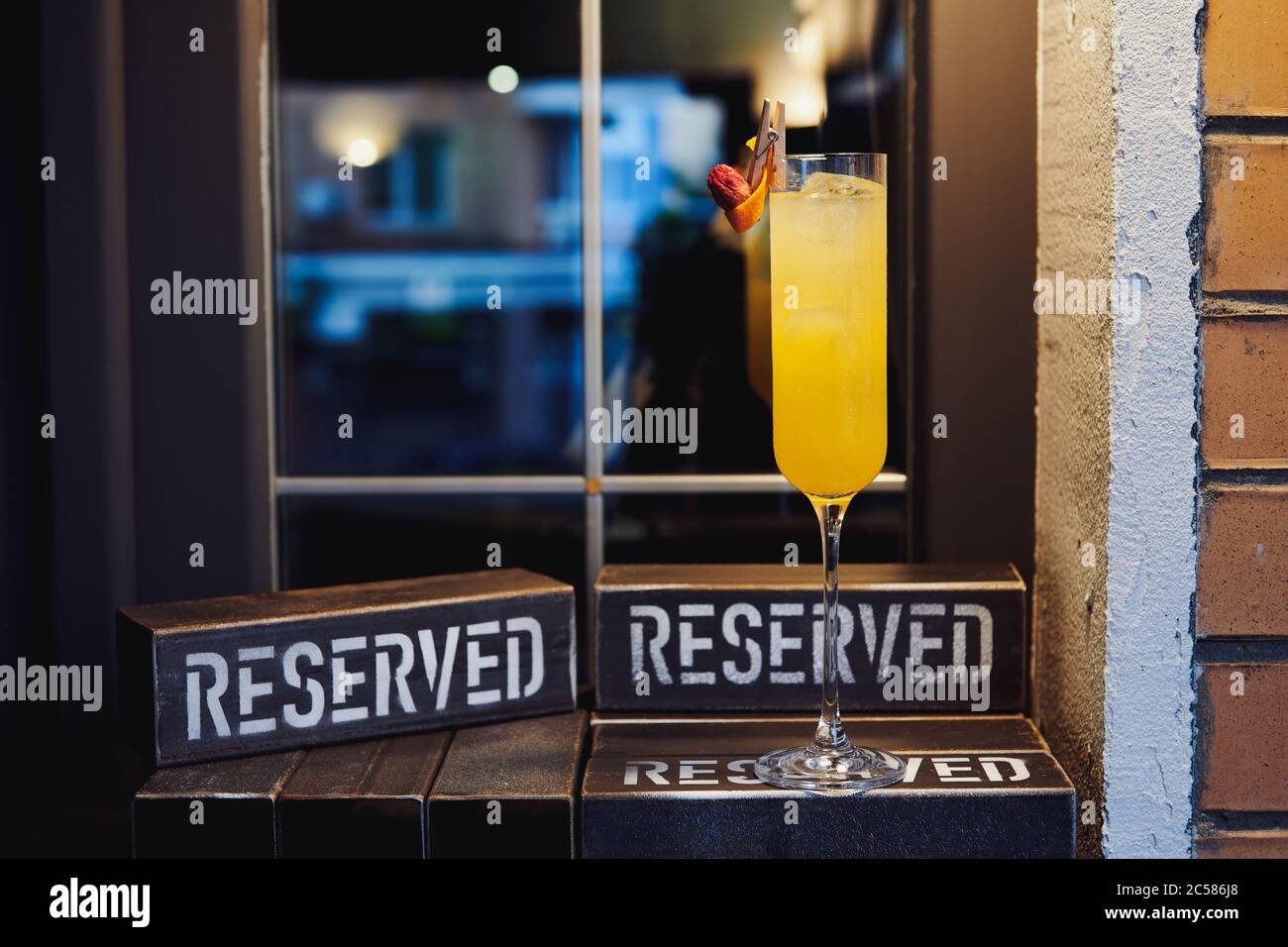 Beautiful yellow alcohol cocktail in wineglass near the window in the ...