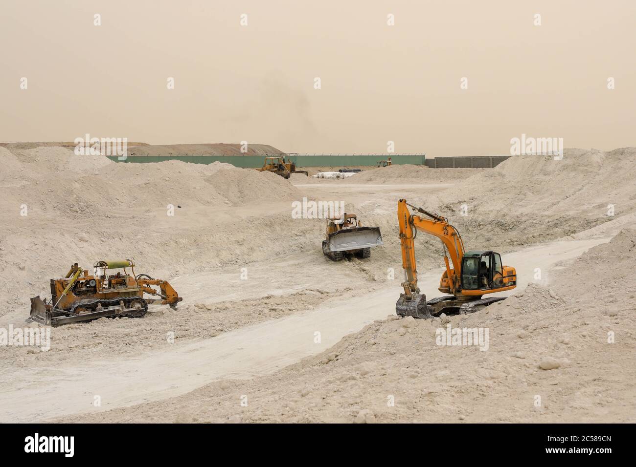 excavator in land work Diggers at work in sand field Stock Photo - Alamy