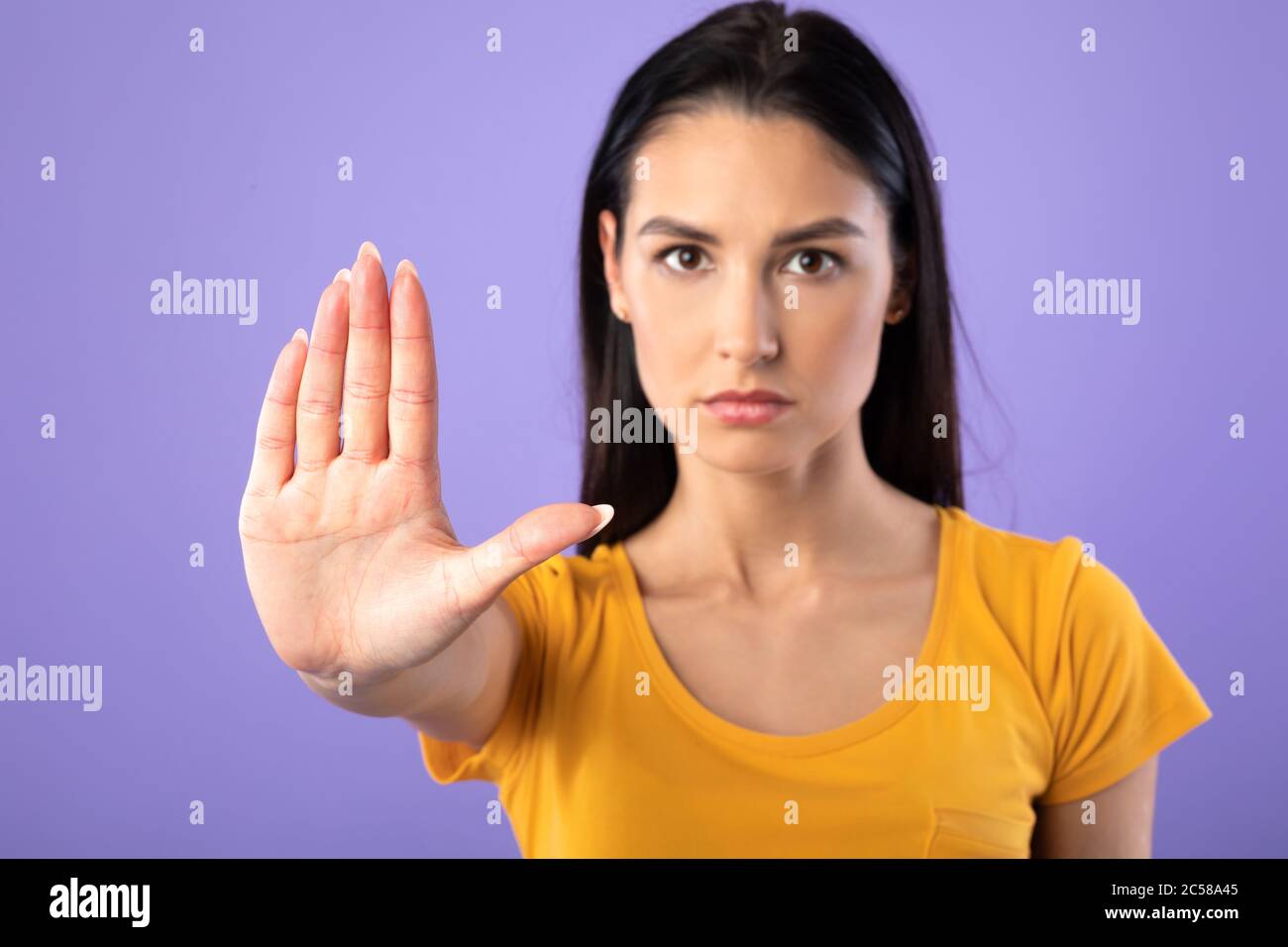 Serious girl showing stop sign with hand Stock Photo - Alamy