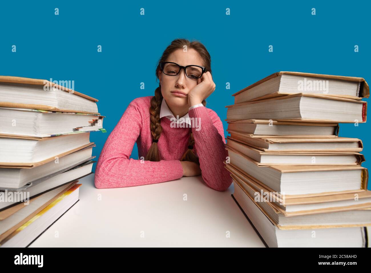 Lack of sleep concept. Sad girl among books Stock Photo - Alamy