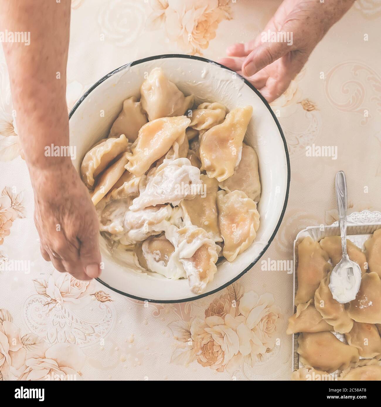 Hands of an unrecognizable woman cooking homemade dumplings with sour ...