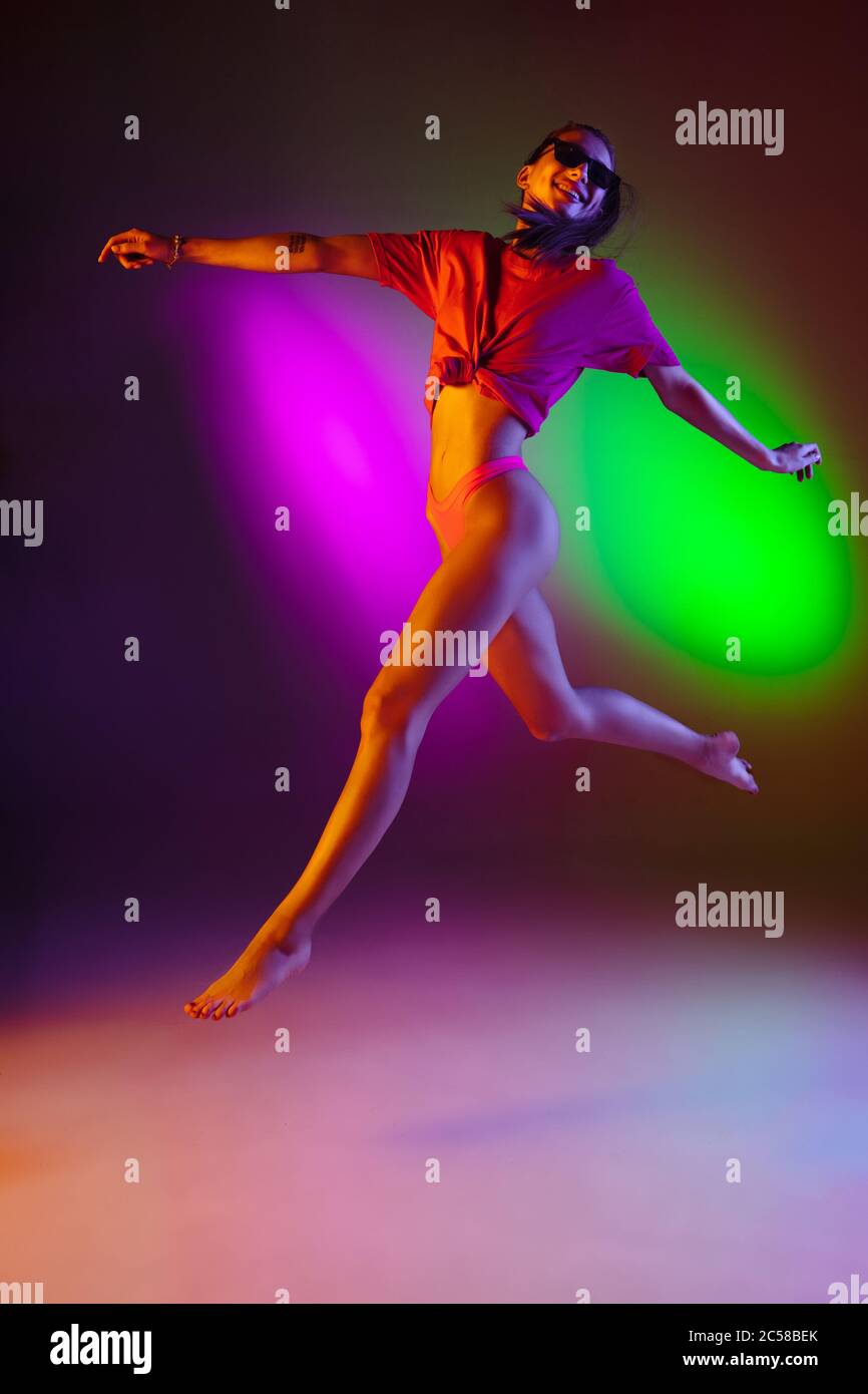Seductive young girl' portrait on bicolored neon studio background in ...