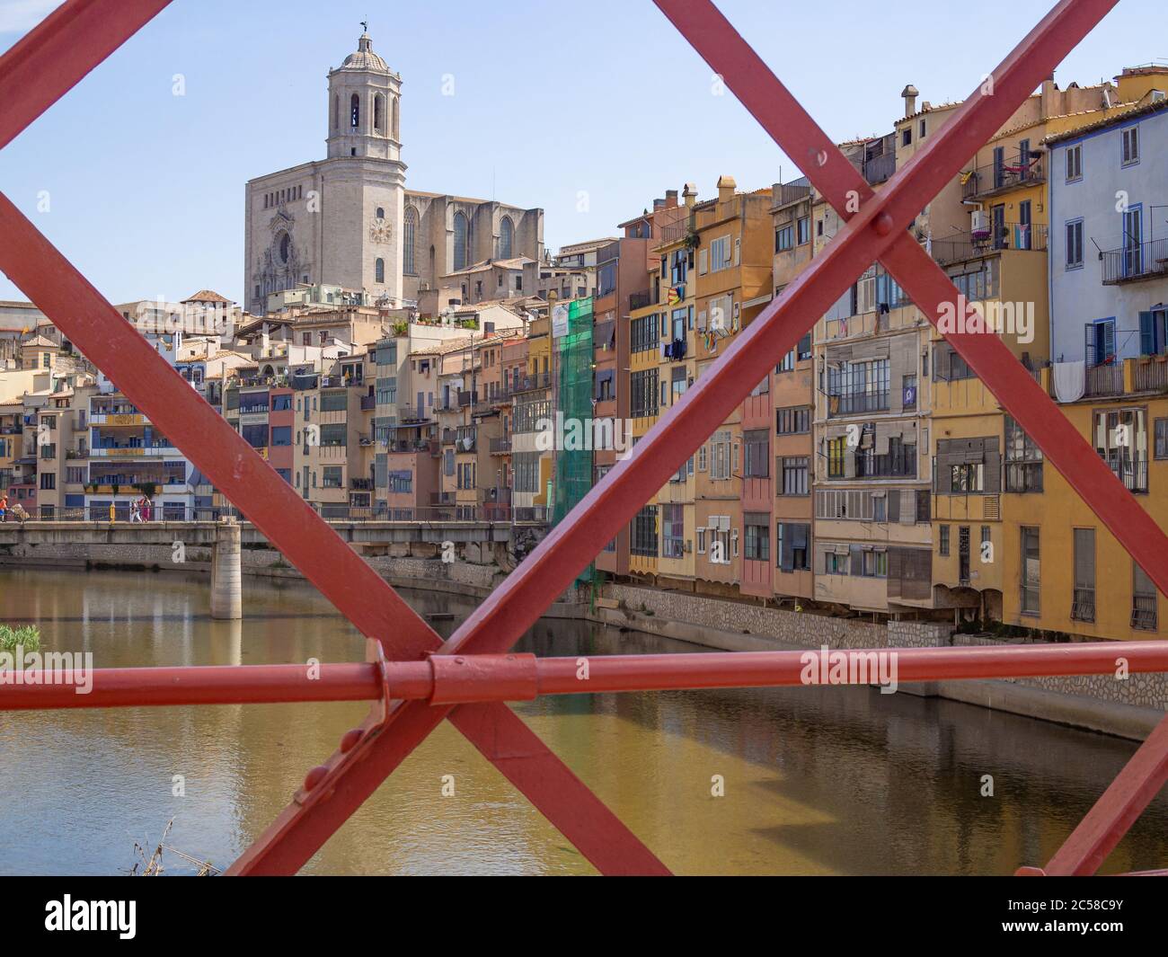 Girona City (Spain) view trough the red grid of the Eiffel bridge ...