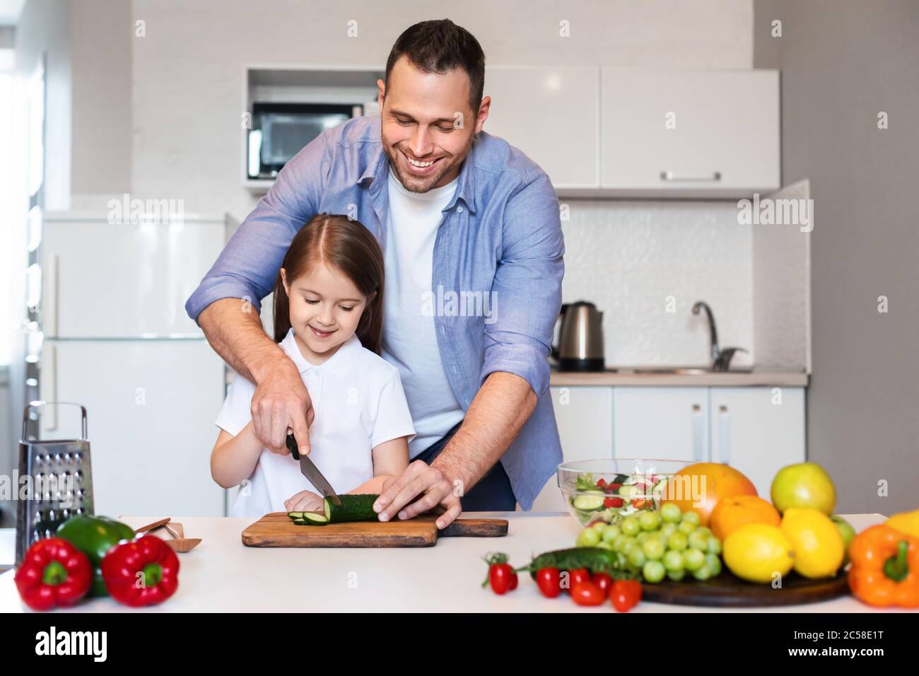 Happy Father And Daughter Cooking Together Cutting Vegetables In ...
