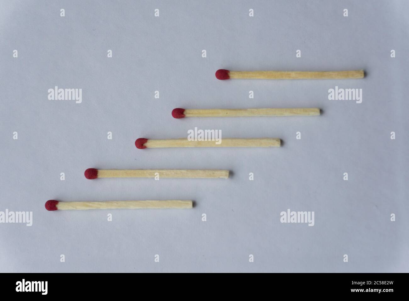 wooden matches lie in a row close up on a white background top view ...