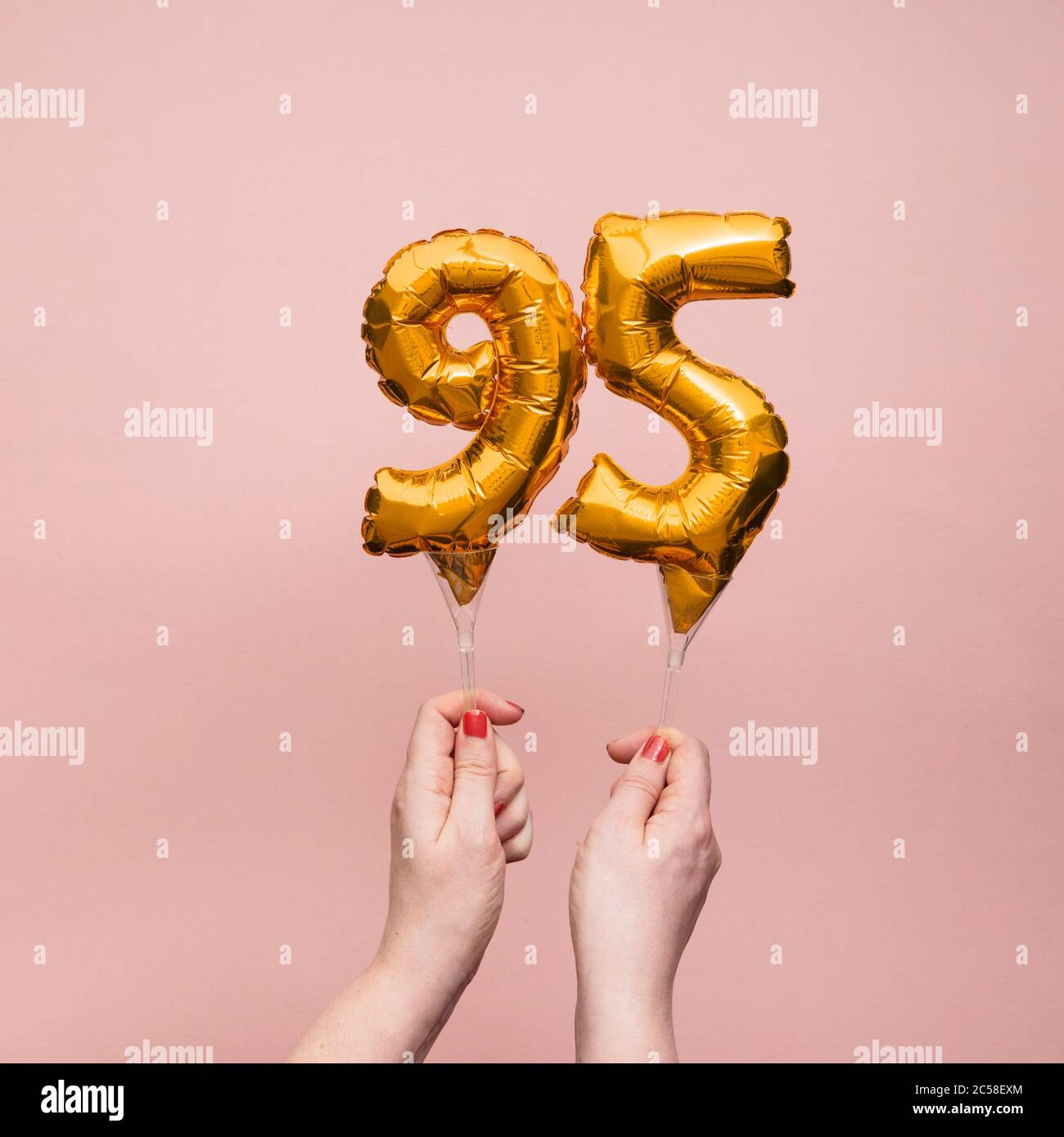 Female hand holding a number 95 birthday anniversary celebration gold ...