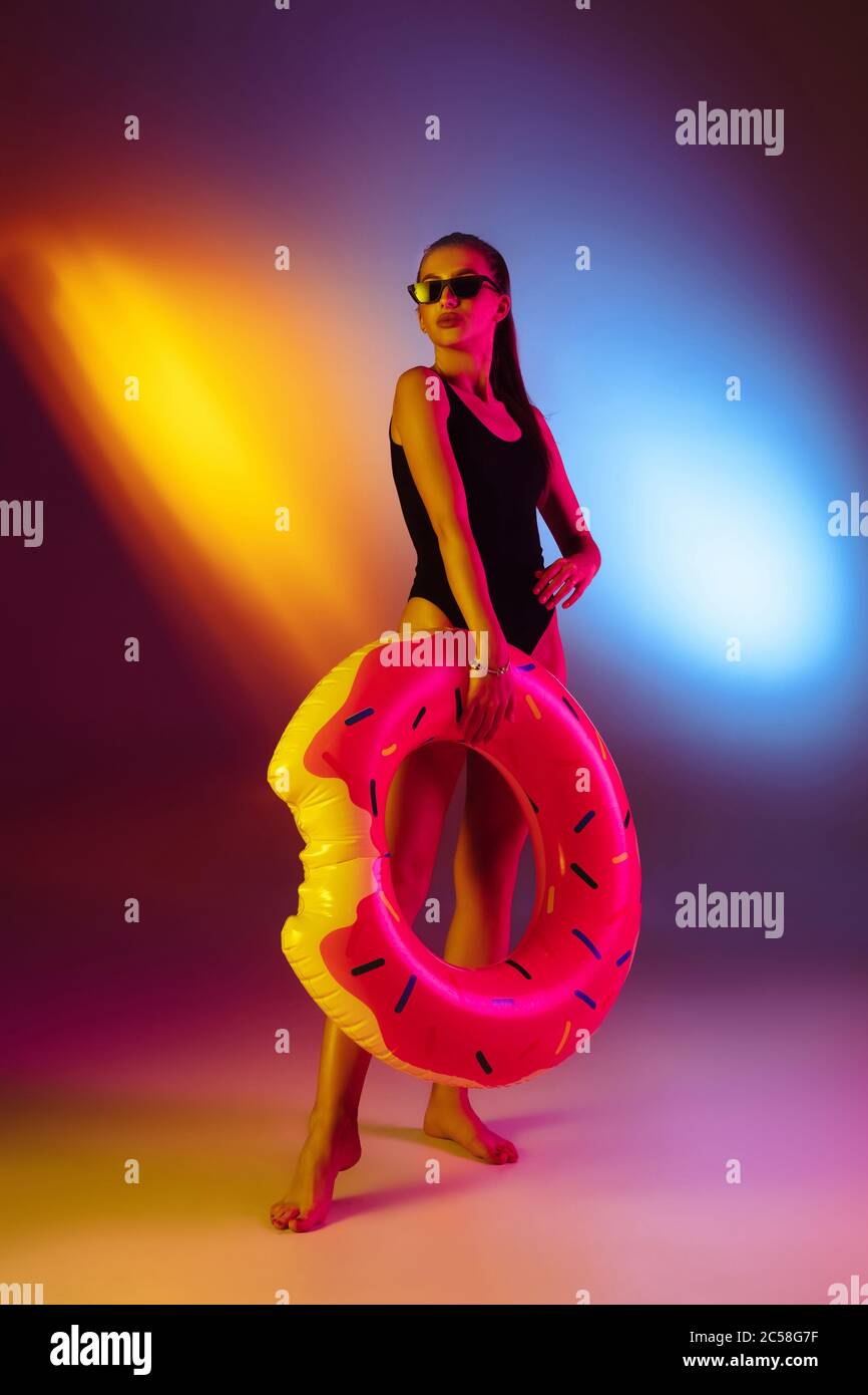 Seductive young girl' portrait on bicolored neon studio background in ...