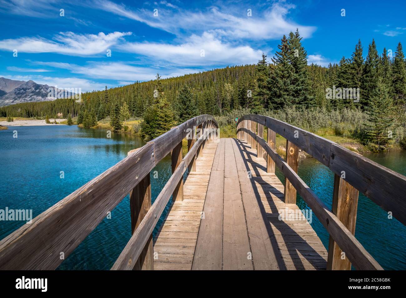 Beautiful wooden bridge spanning across Cascade Ponds with Mount Astley ...