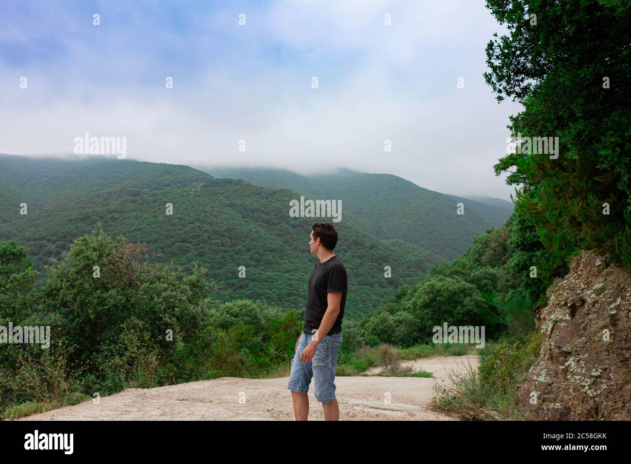 Side view of young caucasian male wearing black shirt jean shorts ...