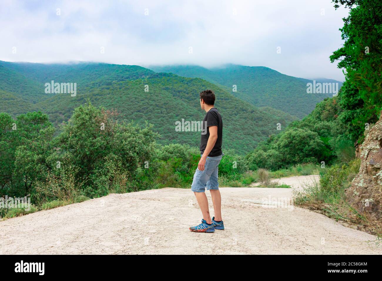 Side view of young caucasian male wearing black shirt jean shorts ...