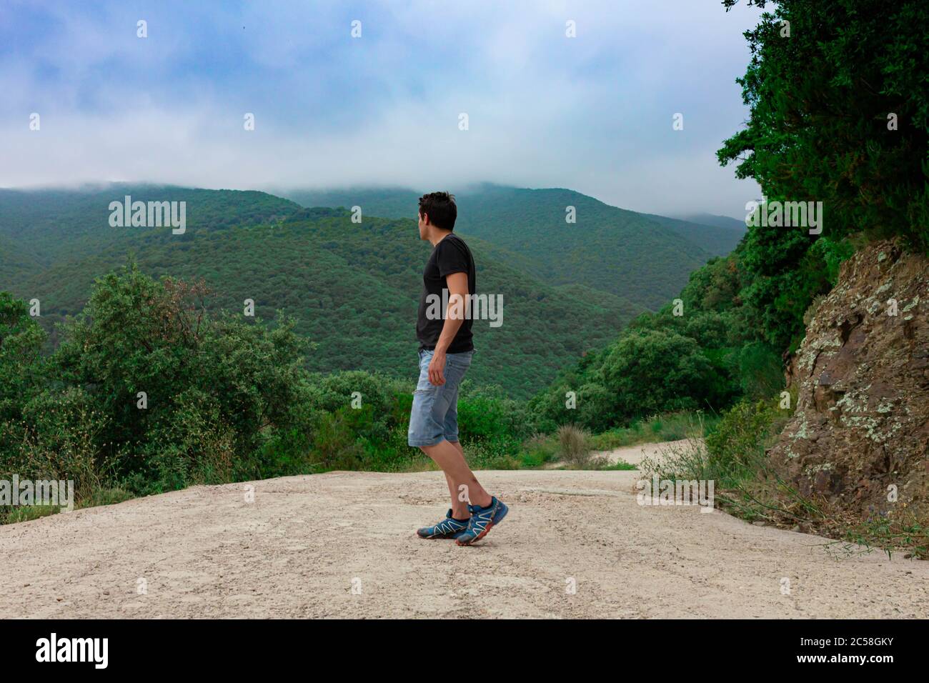 Side view of young caucasian male wearing black shirt jean shorts ...