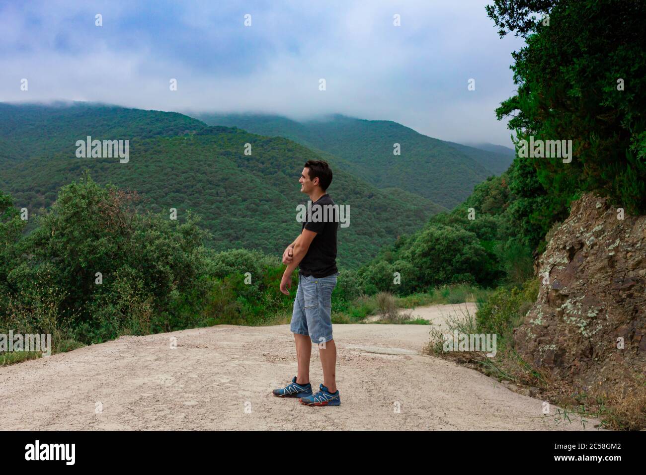 Side view of young caucasian male wearing black shirt jean shorts ...