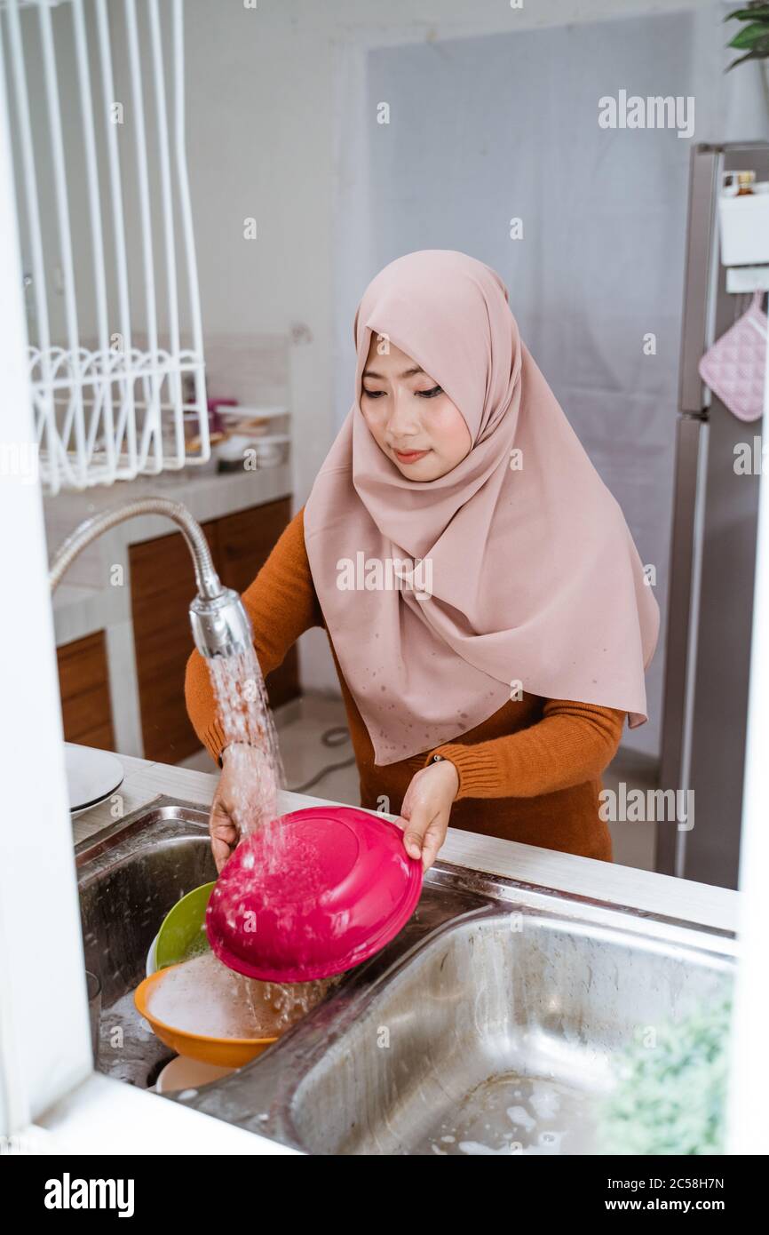 muslim woman doing chores and washing the dishes Stock Photo - Alamy