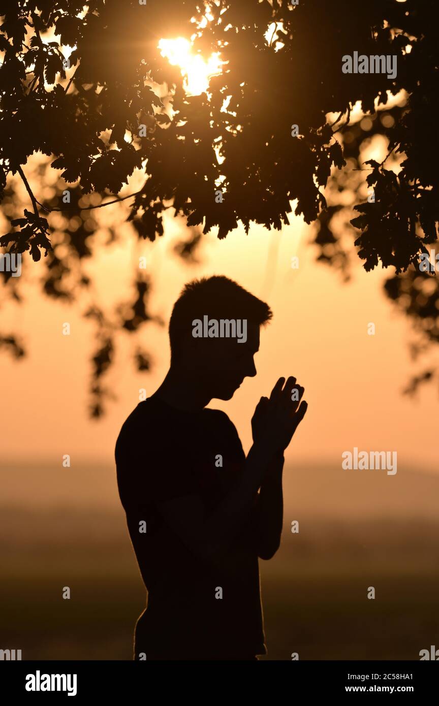 Young sad man praying hi-res stock photography and images - Alamy