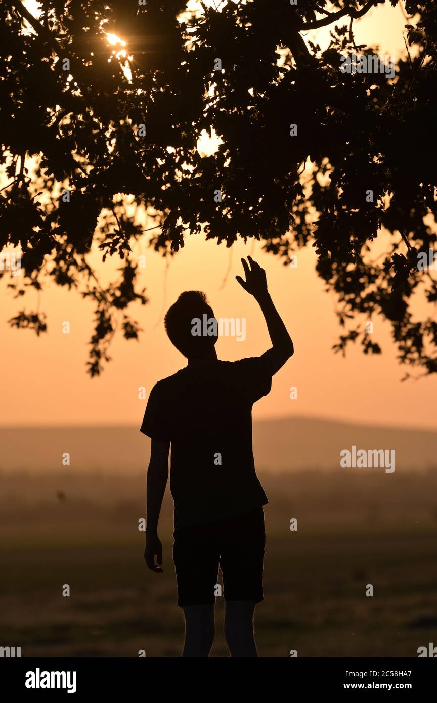 Closeup portrait young man praying hands up at sunset Stock Photo - Alamy