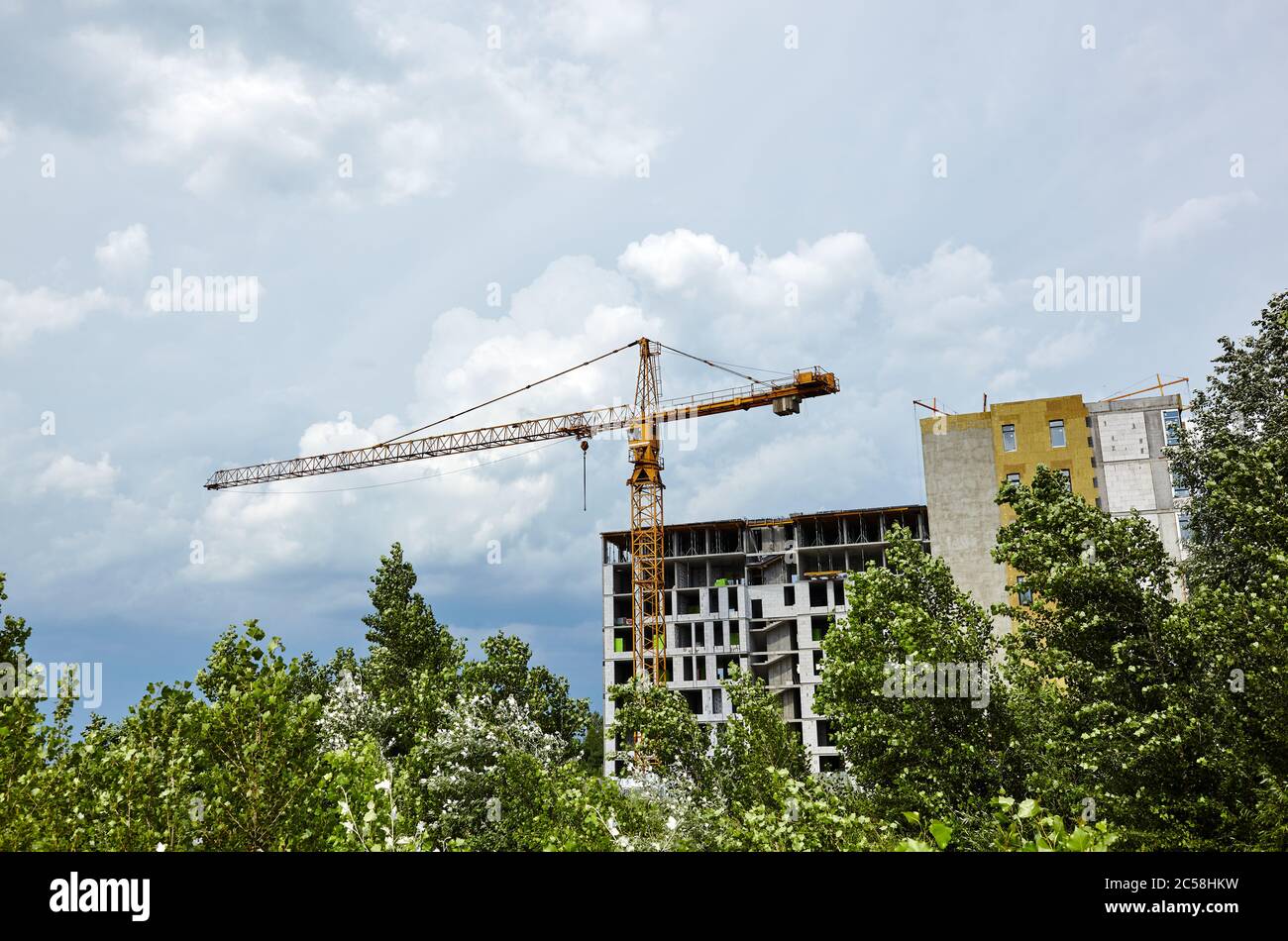 Tower crane building a house. Concrete building under construction ...