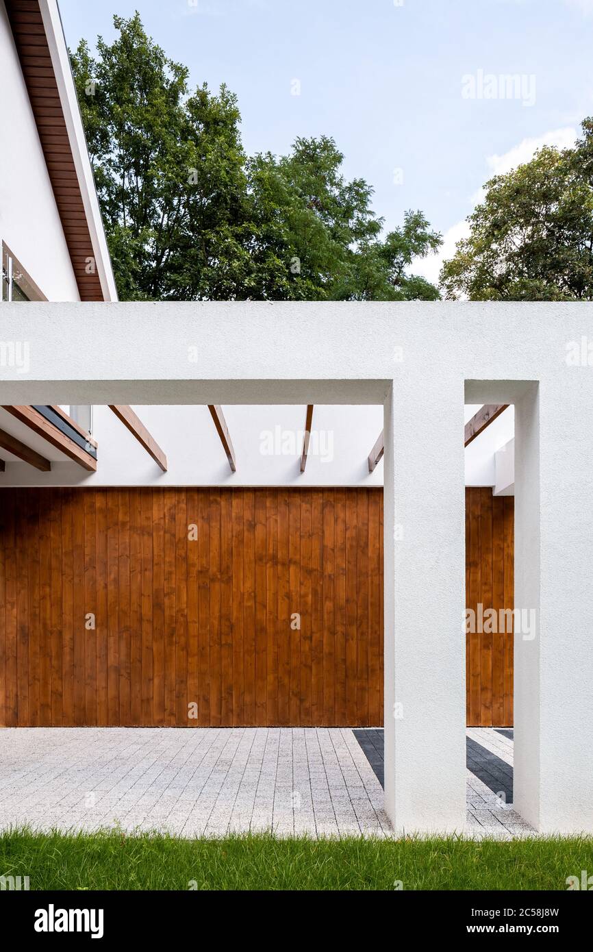 Exterior view of modern house with white elevation, wooden elements and ...