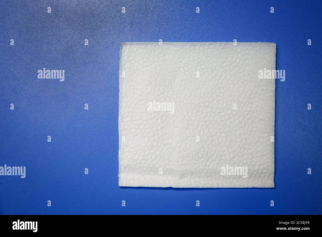 Blank paper napkin isolated on blue background with copy space . White ...